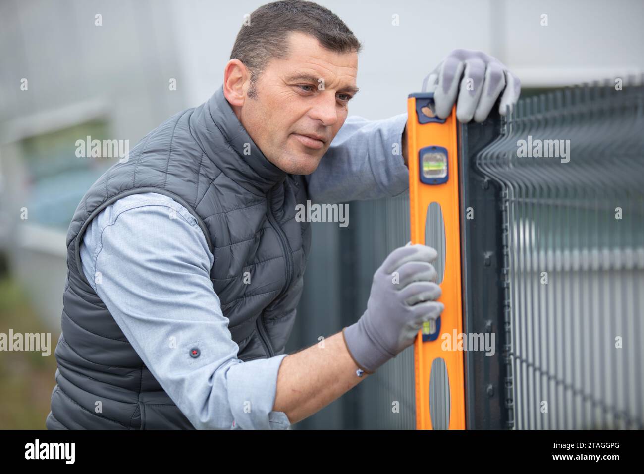fence construction - worker check its level Stock Photo - Alamy