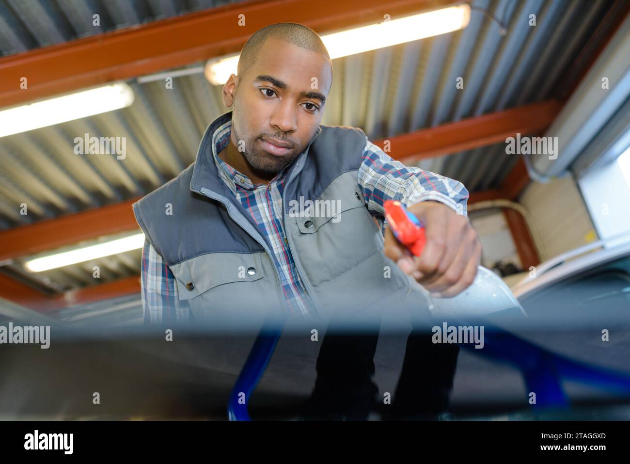 mechanic using spray on automotive component Stock Photo - Alamy