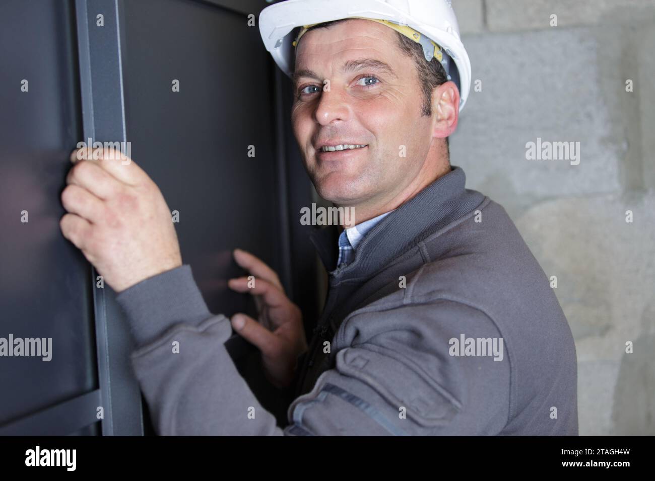 builder in hard hat working with door Stock Photo - Alamy