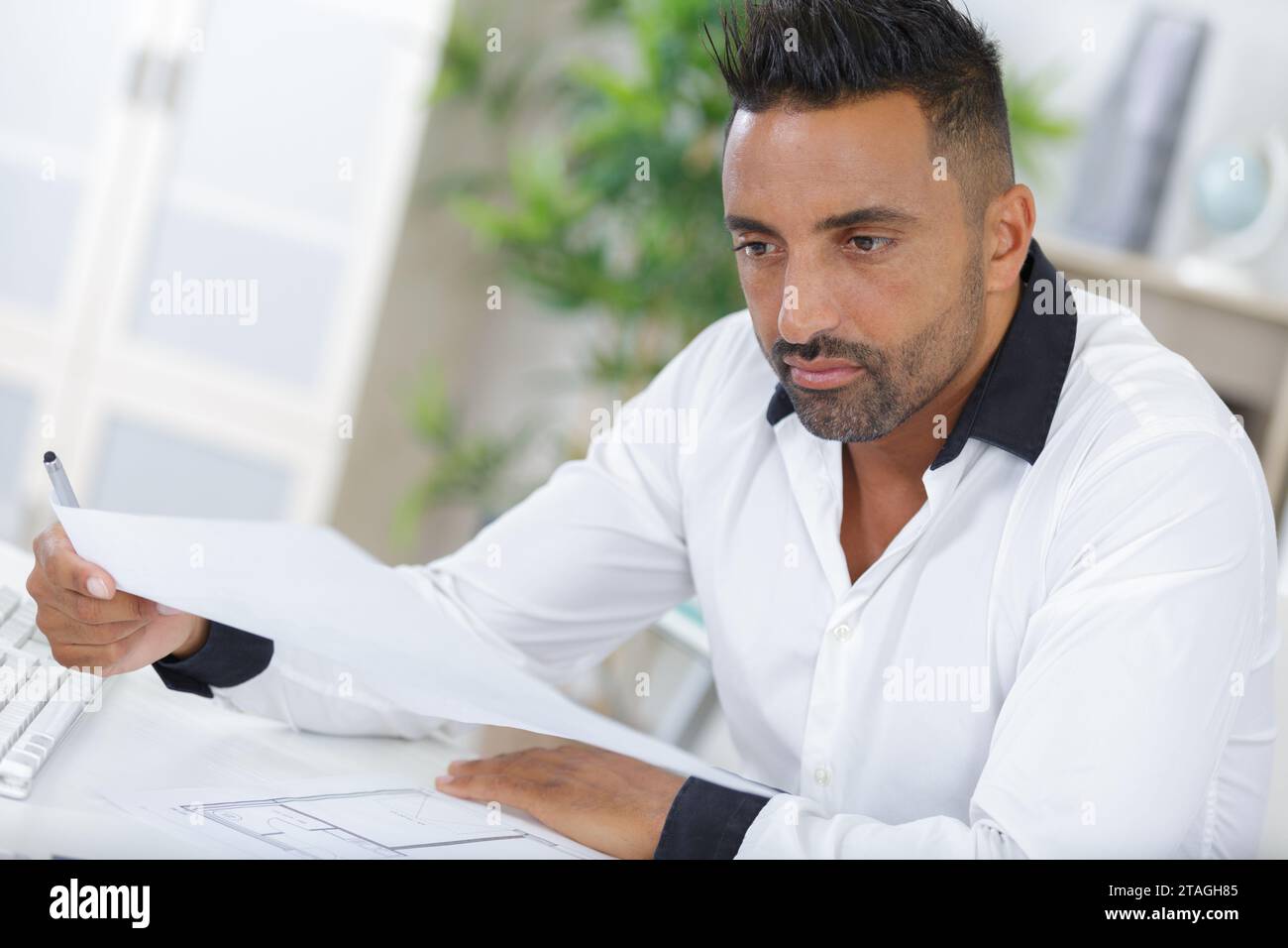 portrait of architect looking at blueprints in office Stock Photo - Alamy