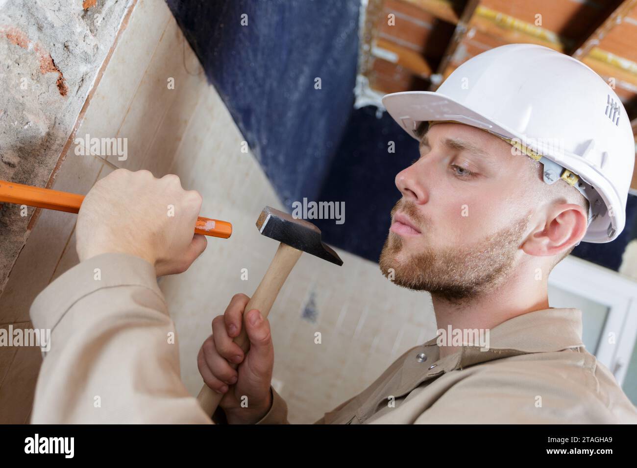 builder hitting a wall with a hammer Stock Photo - Alamy