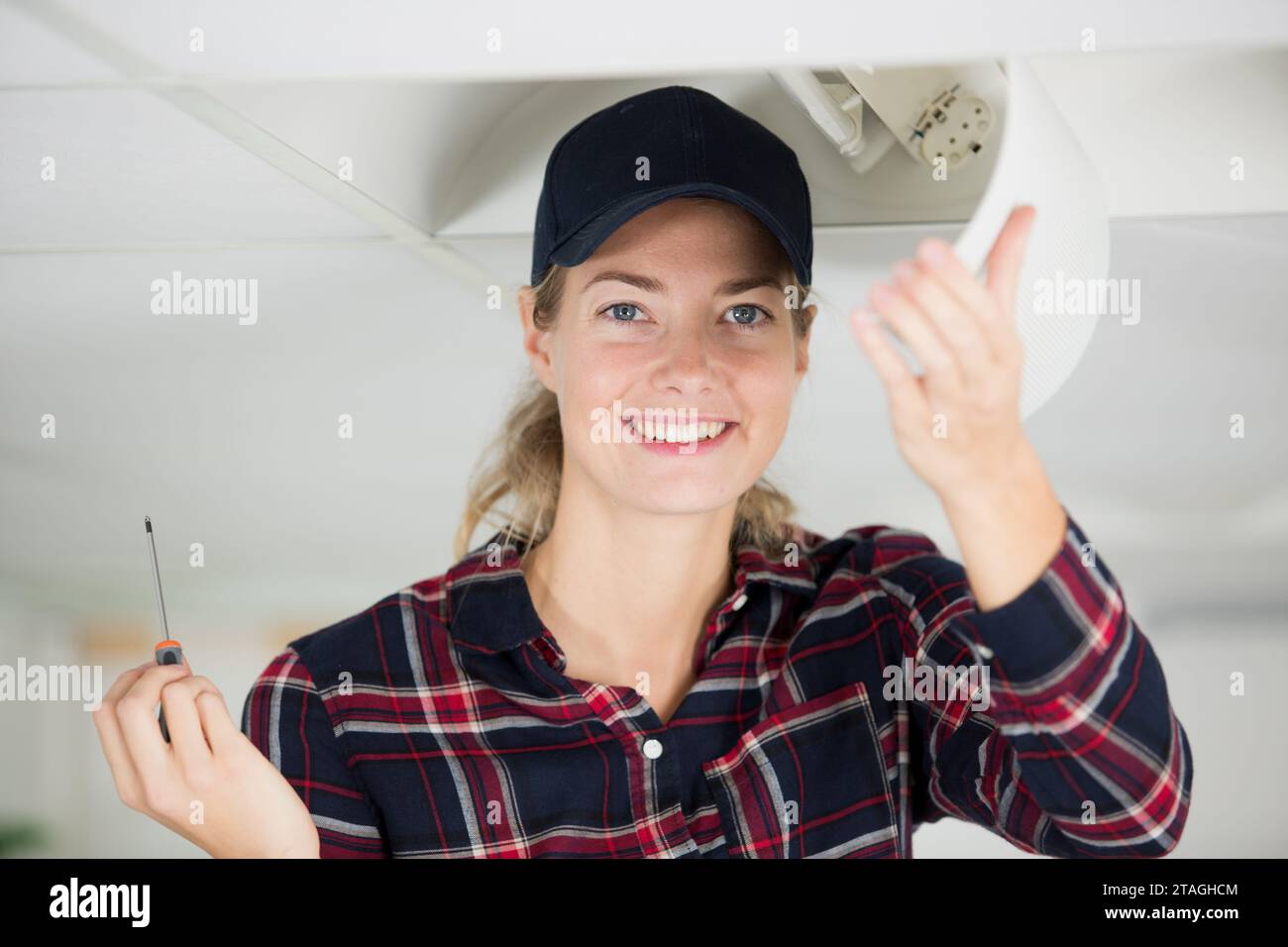 female young electrician installing neon bulb Stock Photo - Alamy