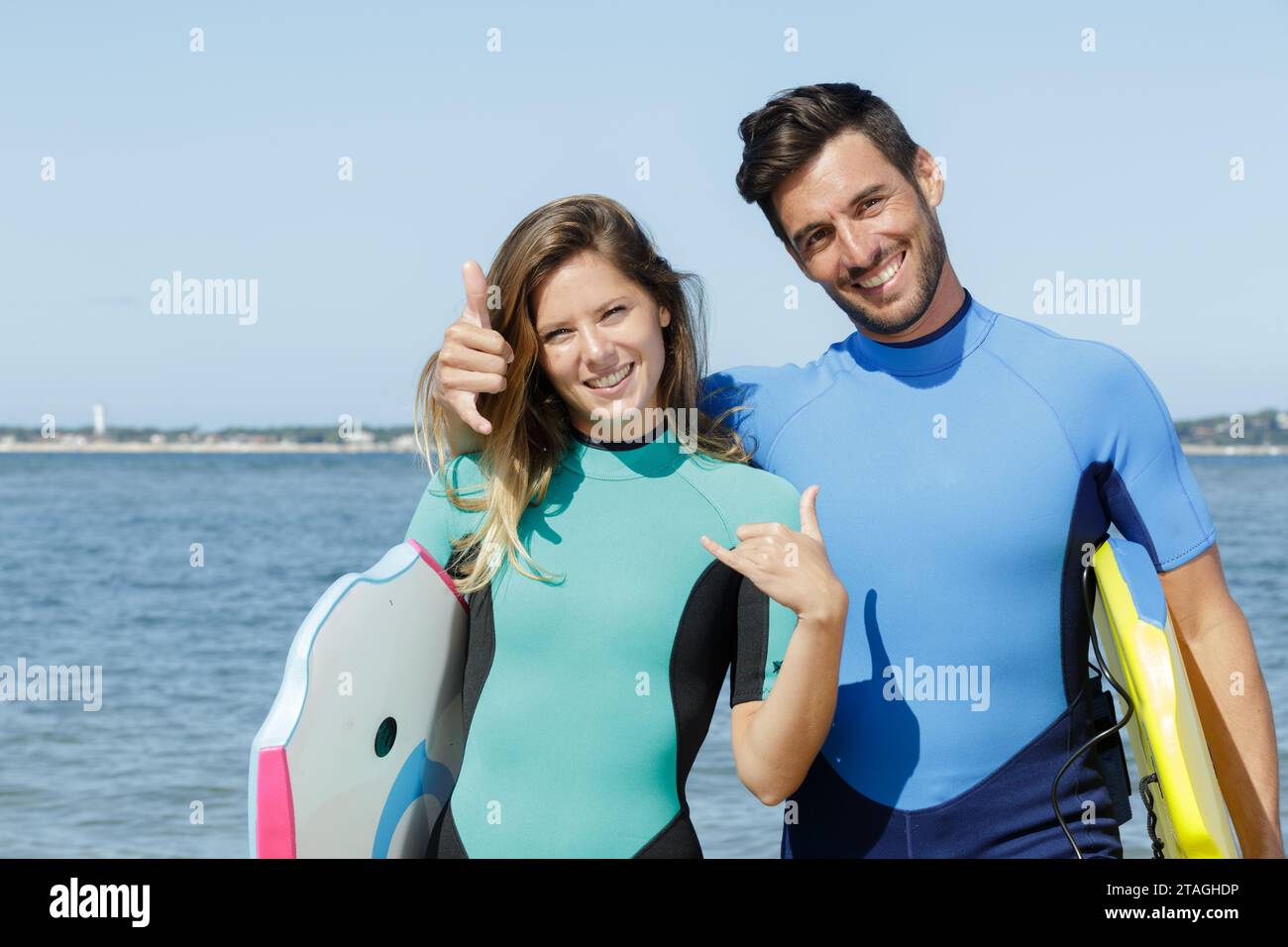 happy couple showing surf signs Stock Photo - Alamy