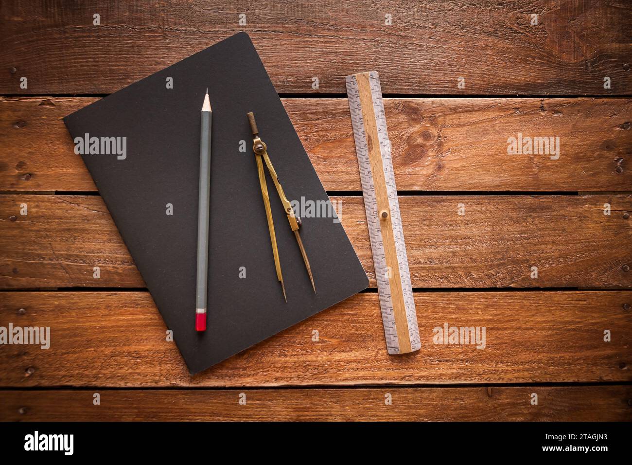 Closed old notebook, pencil, ruler and drawing compas on a rustic ...