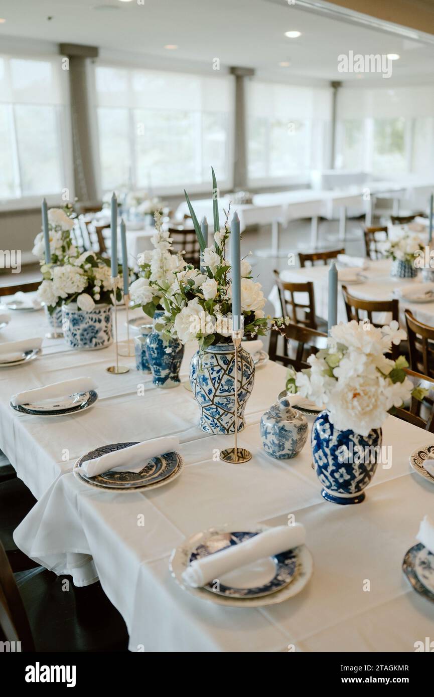 An elegantly set table adorned with white flowers and candles, creating ...