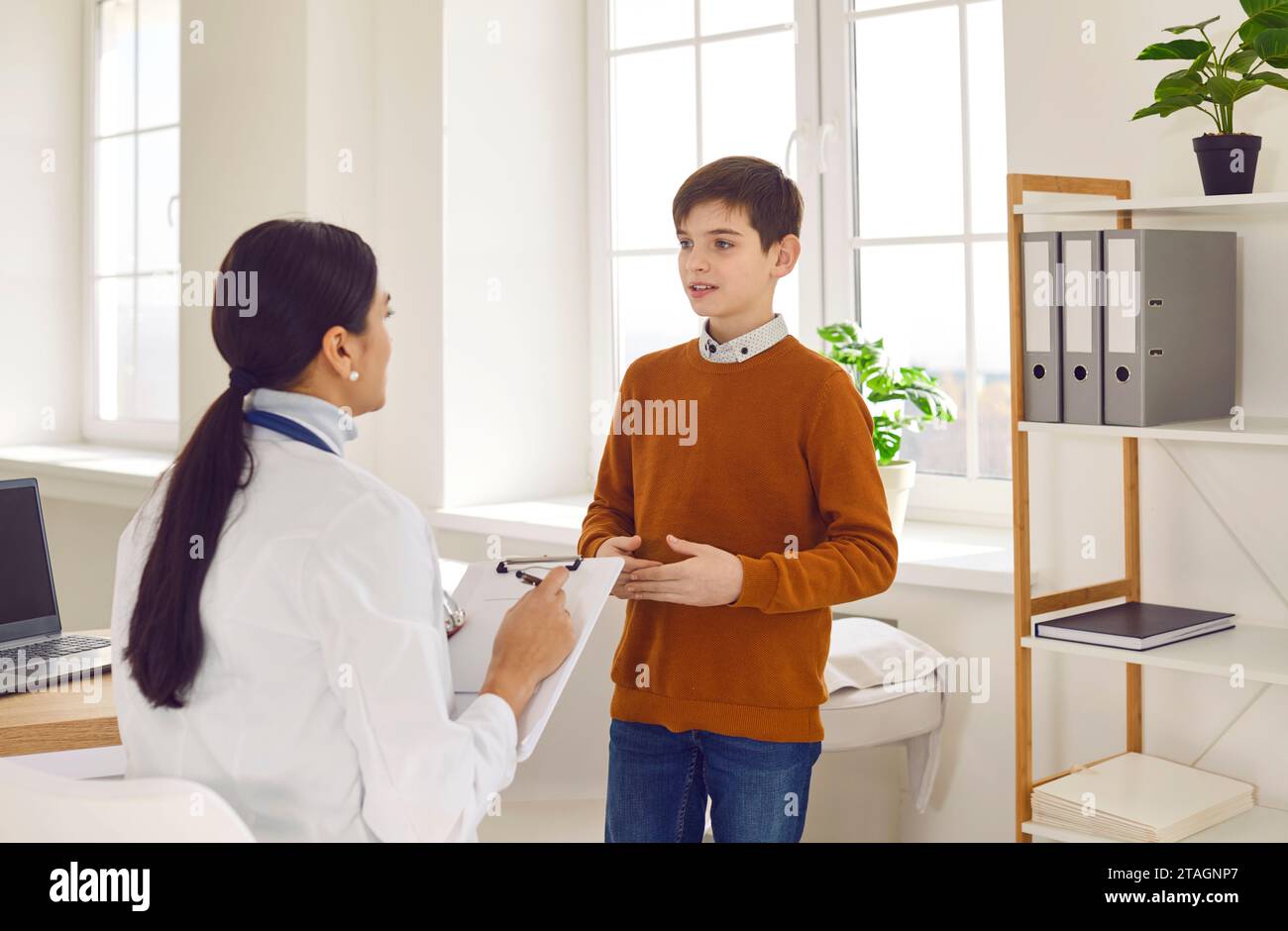 Female doctor talking with a child boy patient during medical ...