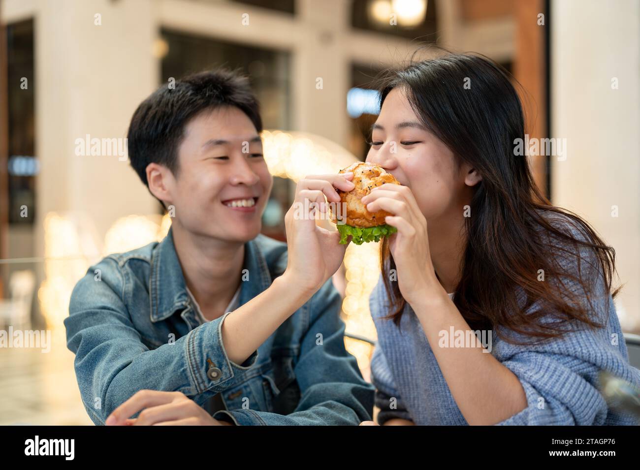 Lovely young couple eating hamburger hi-res stock photography and ...