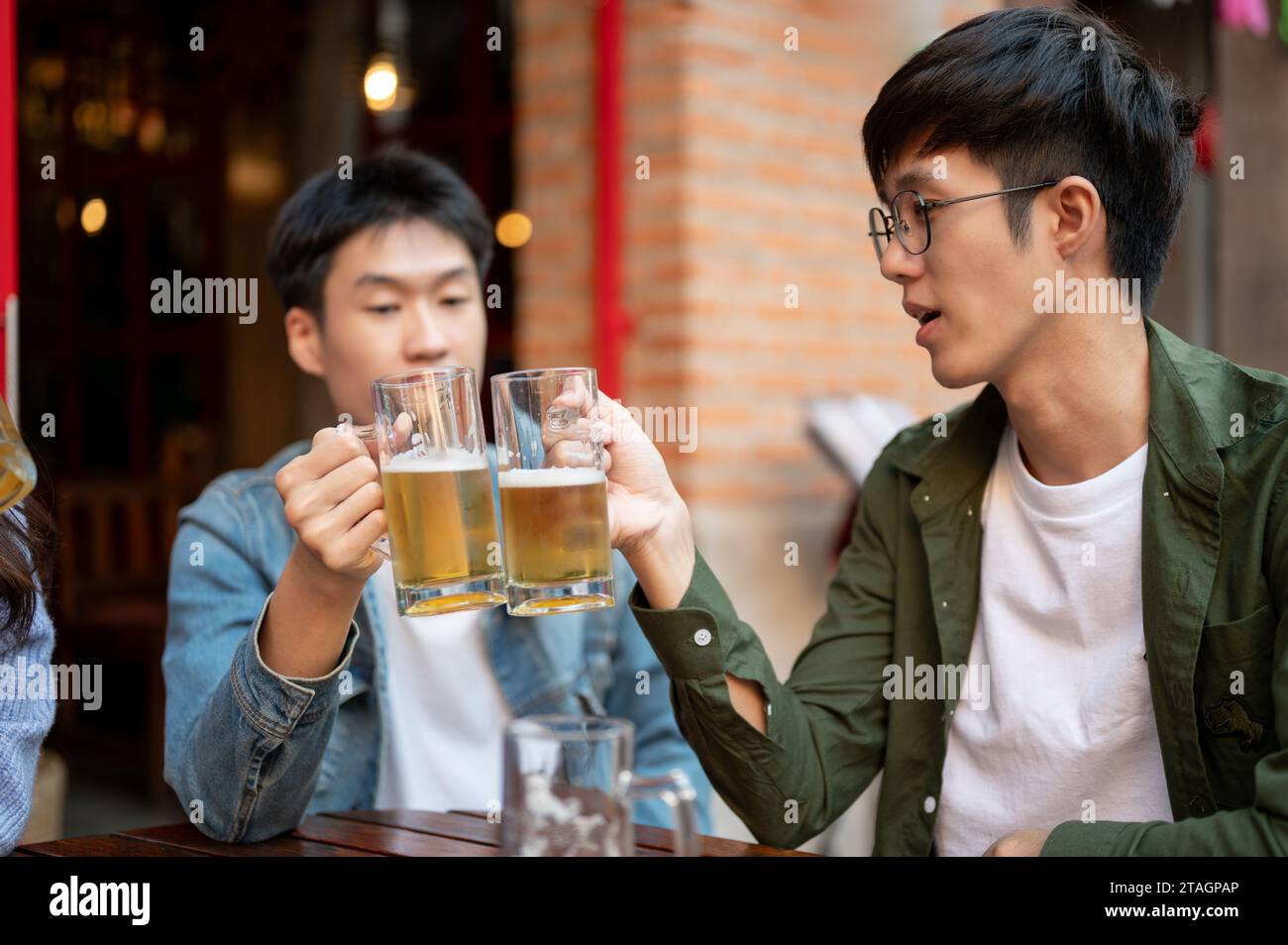 Happy friends cheering in bar hi-res stock photography and images - Alamy