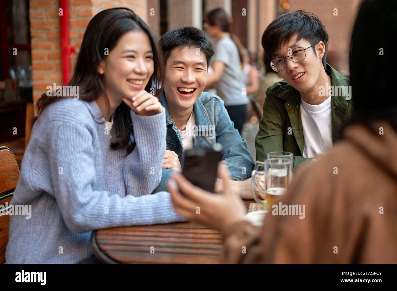 Group of cheerful young Asian friends are enjoying talking while ...