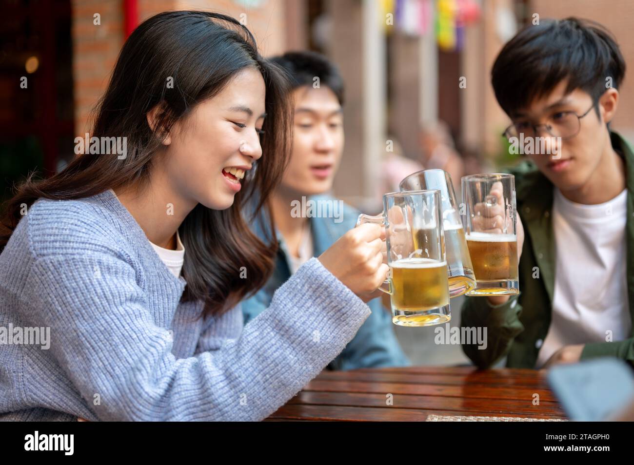 Group of happy young Asian friends are enjoying drinking beers and ...