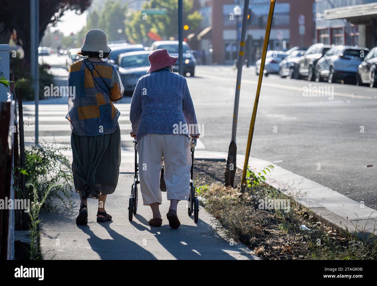 Senior woman walking using a mobility walker on the pedestrian walkway ...