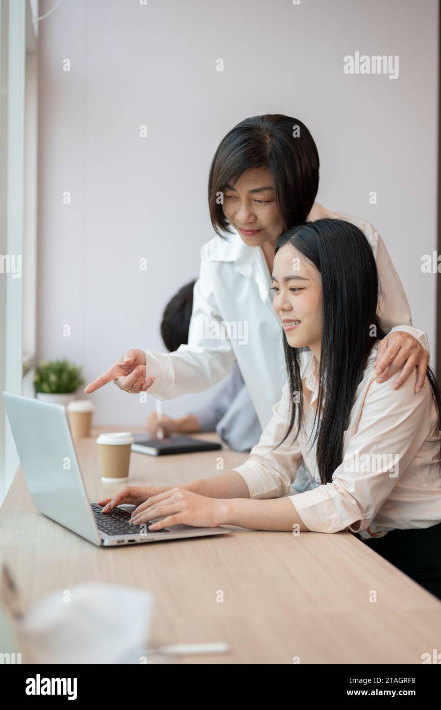 A professional and kind senior Asian female boss is helping and ...