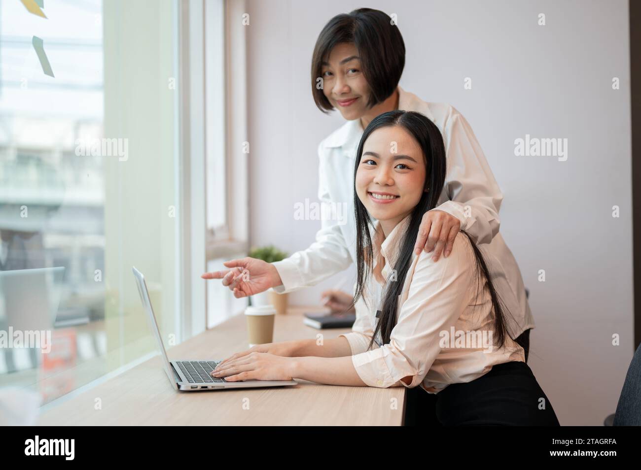 A professional and kind senior Asian female boss is helping and ...
