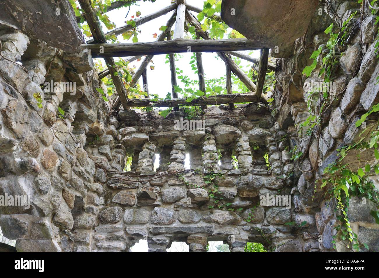 Remnants of old collapsed timber roof on an abandoned rustic stone ...
