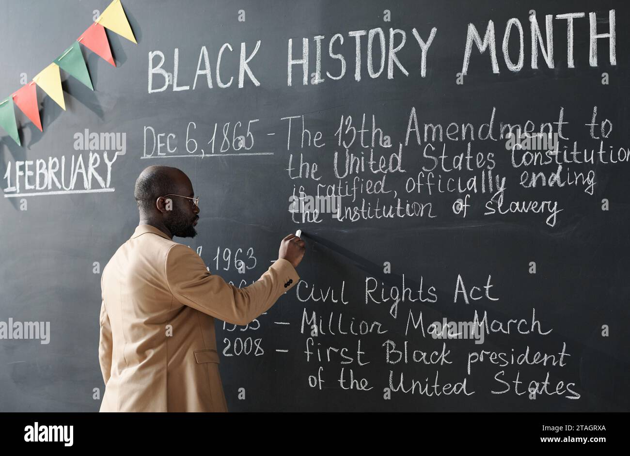African American teacher writing information about Black History Month ...