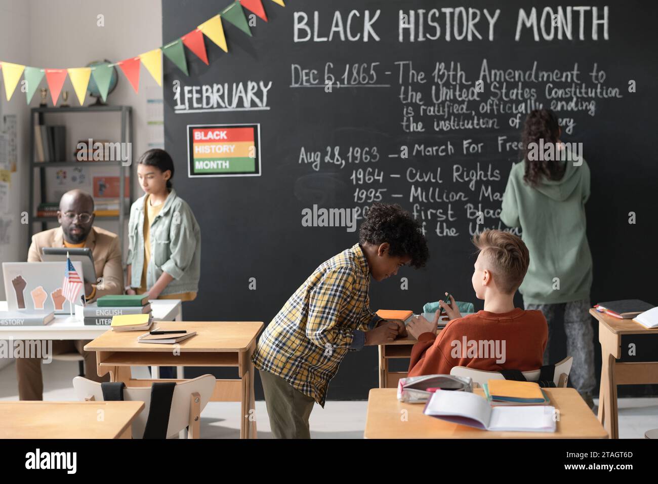 Group of school children cooperating together with teacher in the ...