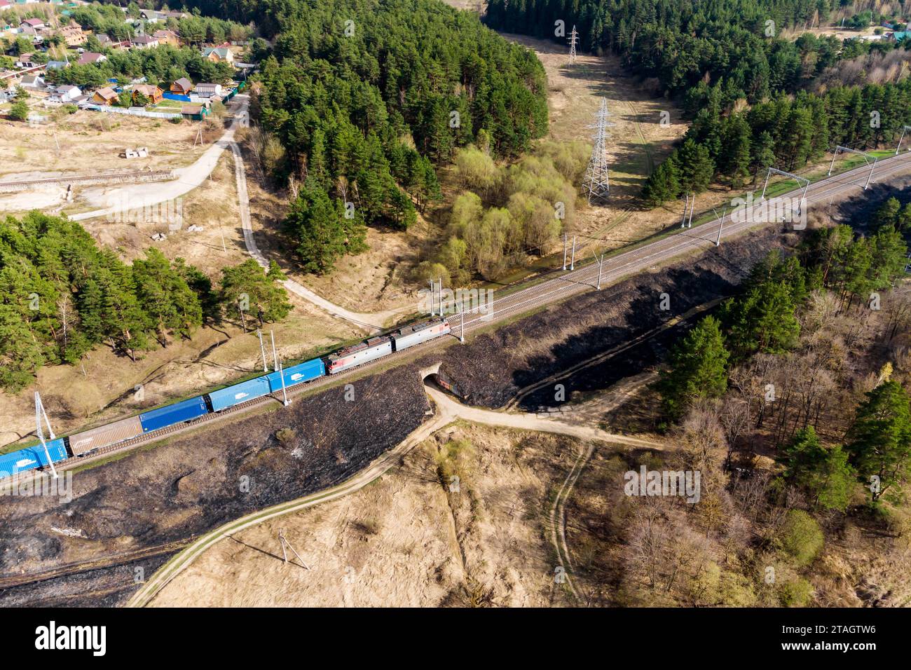 Railway embankment in rural area with moving freight train, view from ...