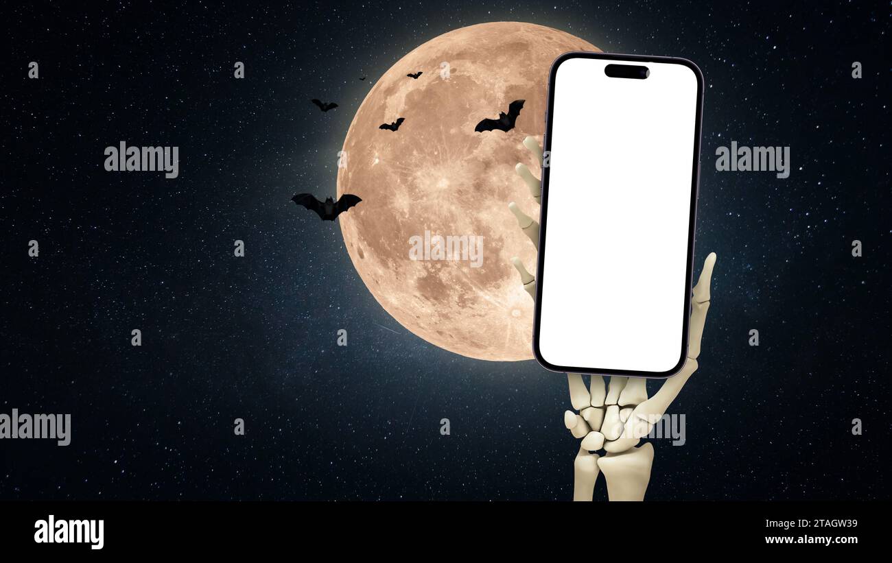 Skeleton hand holds a mock up smartphone with the full moon and bats, a ...