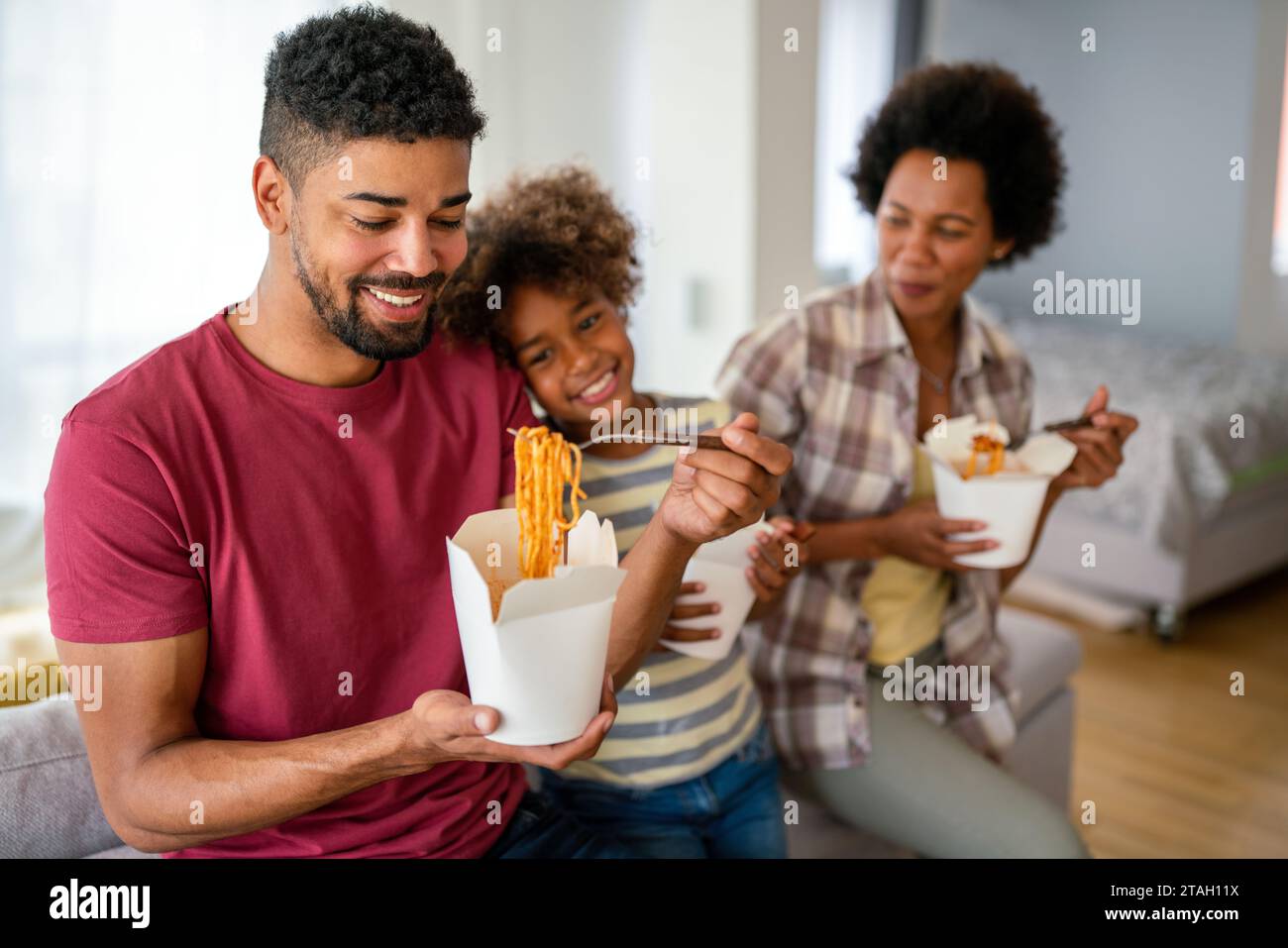 Happy african family eating at living room and enjoying time together ...