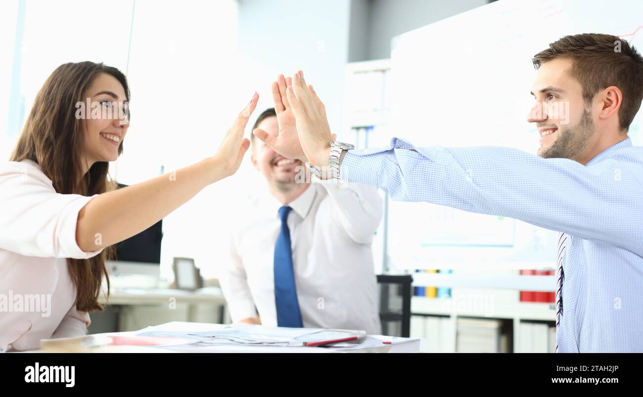 Happy business team high five in office Stock Photo - Alamy