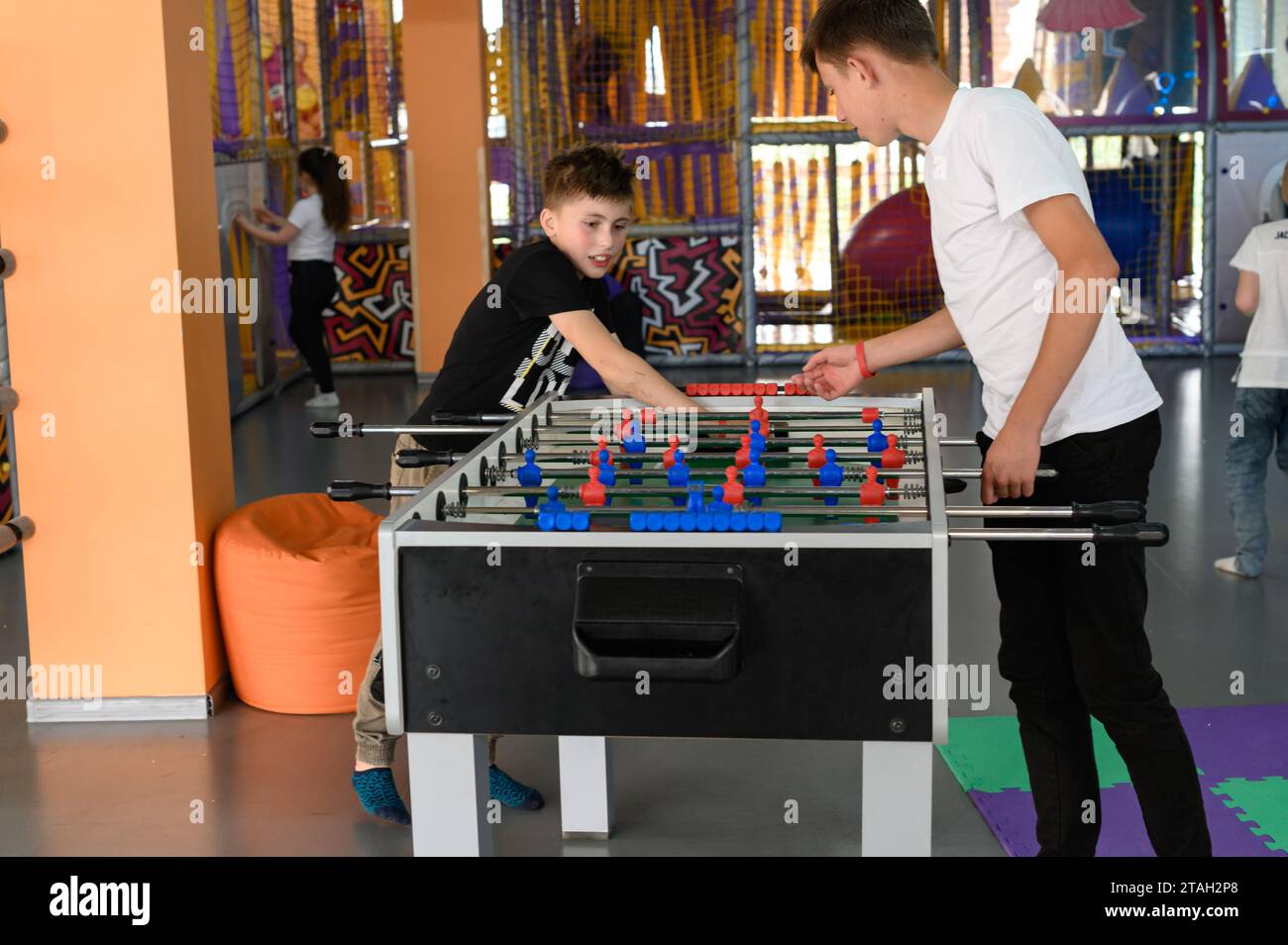 Two boys in the game room playing table football, mental and active ...