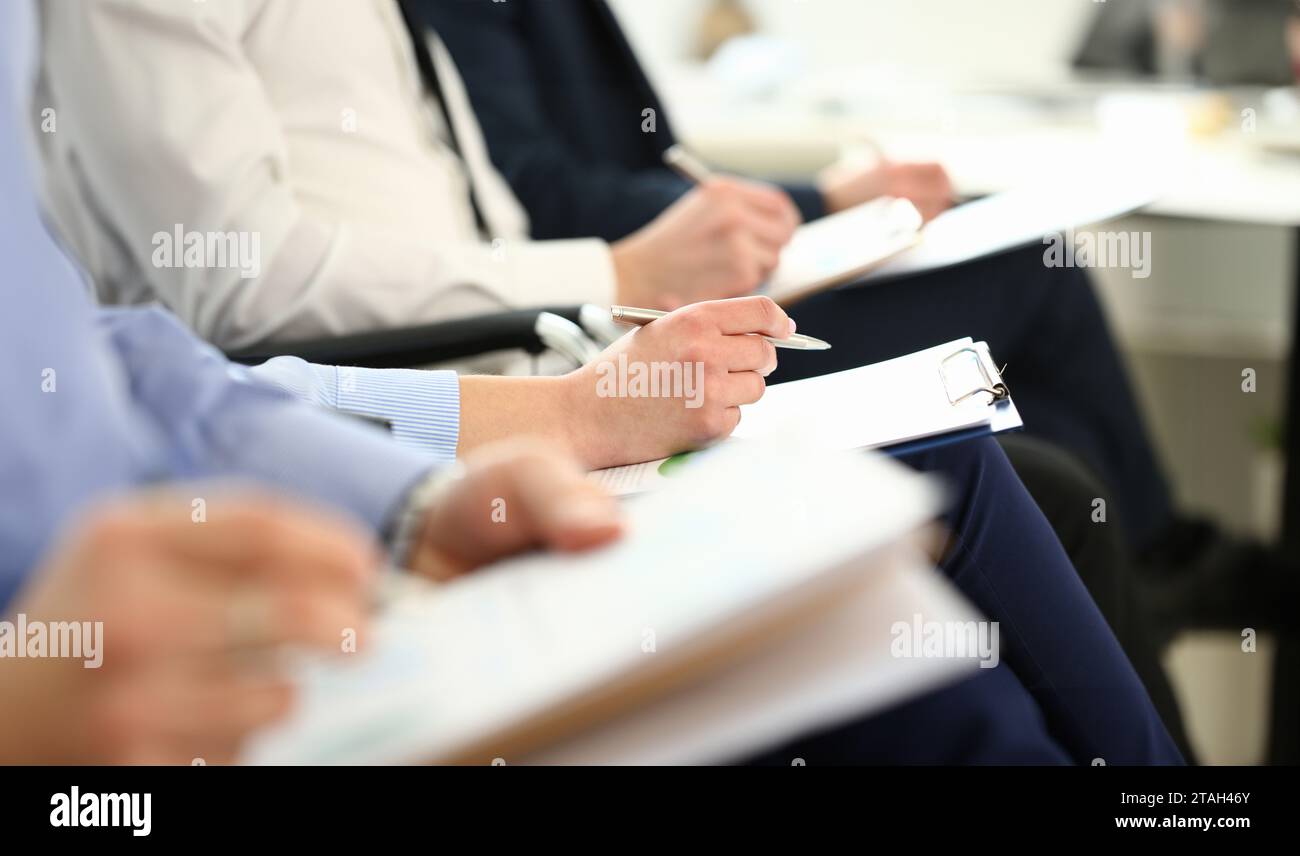 Businessmen are holding documents while taking notes at seminar Stock ...
