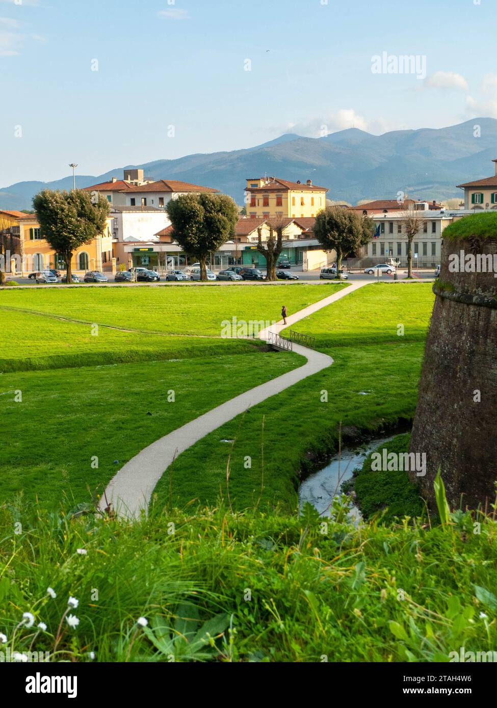 view from the walls of Lucca out to the outer city, a winding path with ...