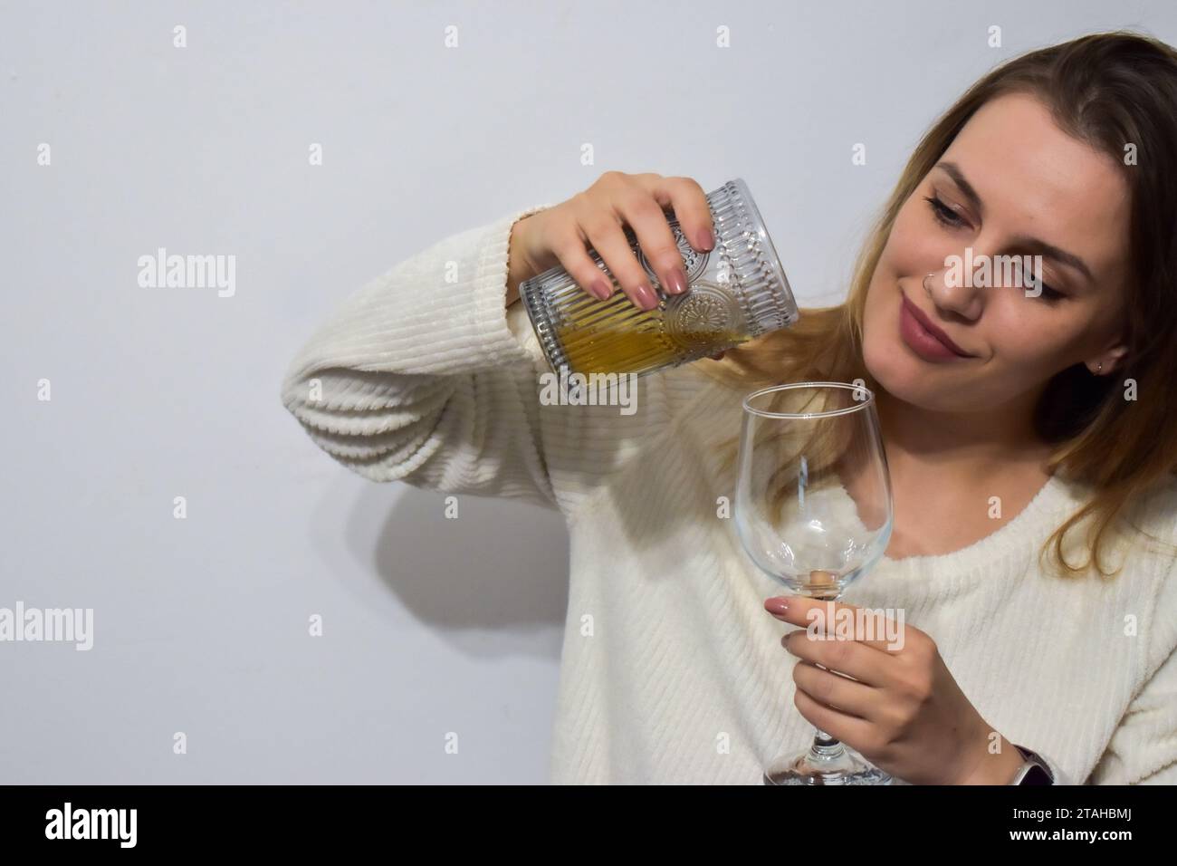 Portrait of a cheerful Caucasian woman pouring a refreshing liquid into ...