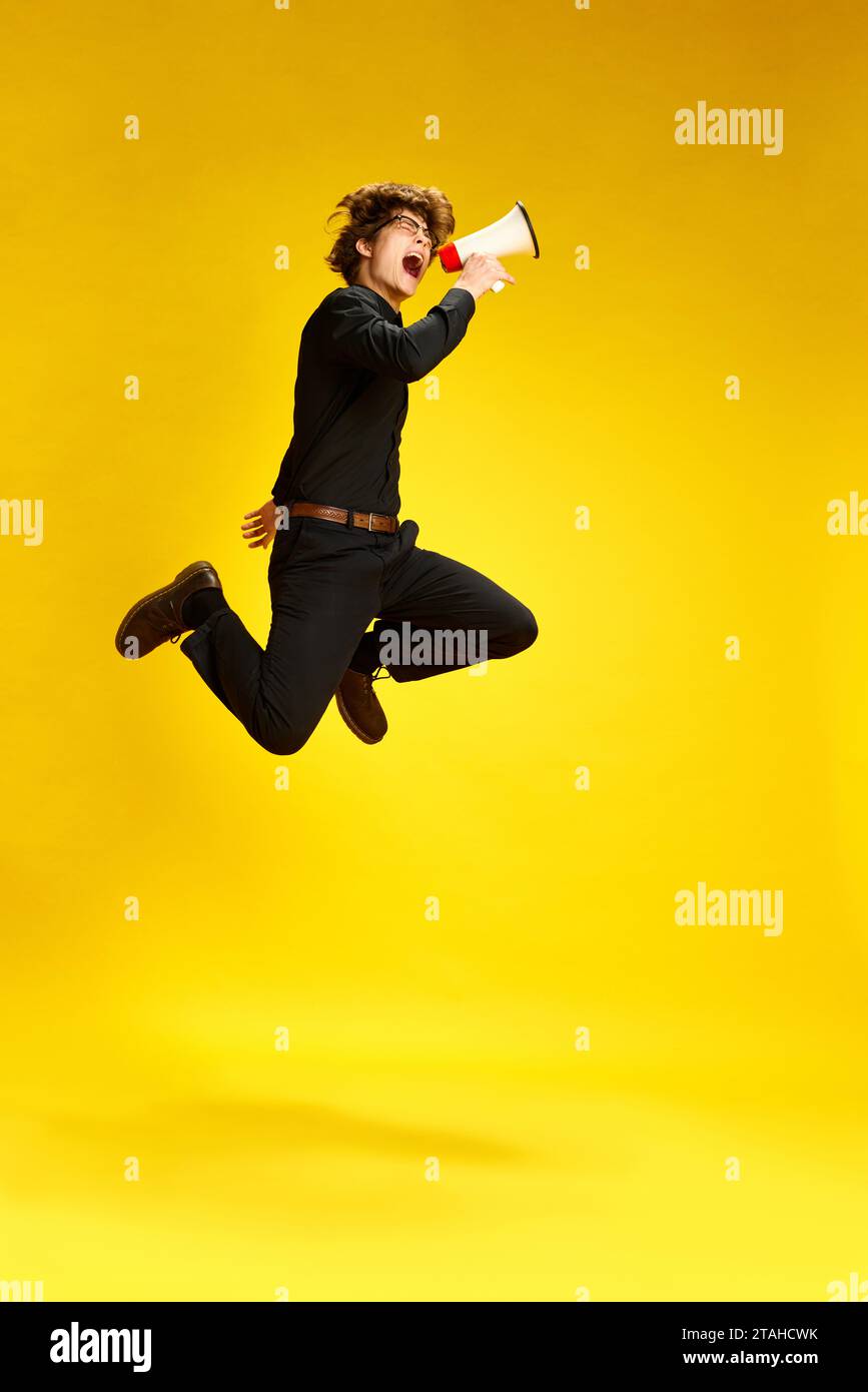 Young man shouting, screaming about new sales to loudspeaker while ...