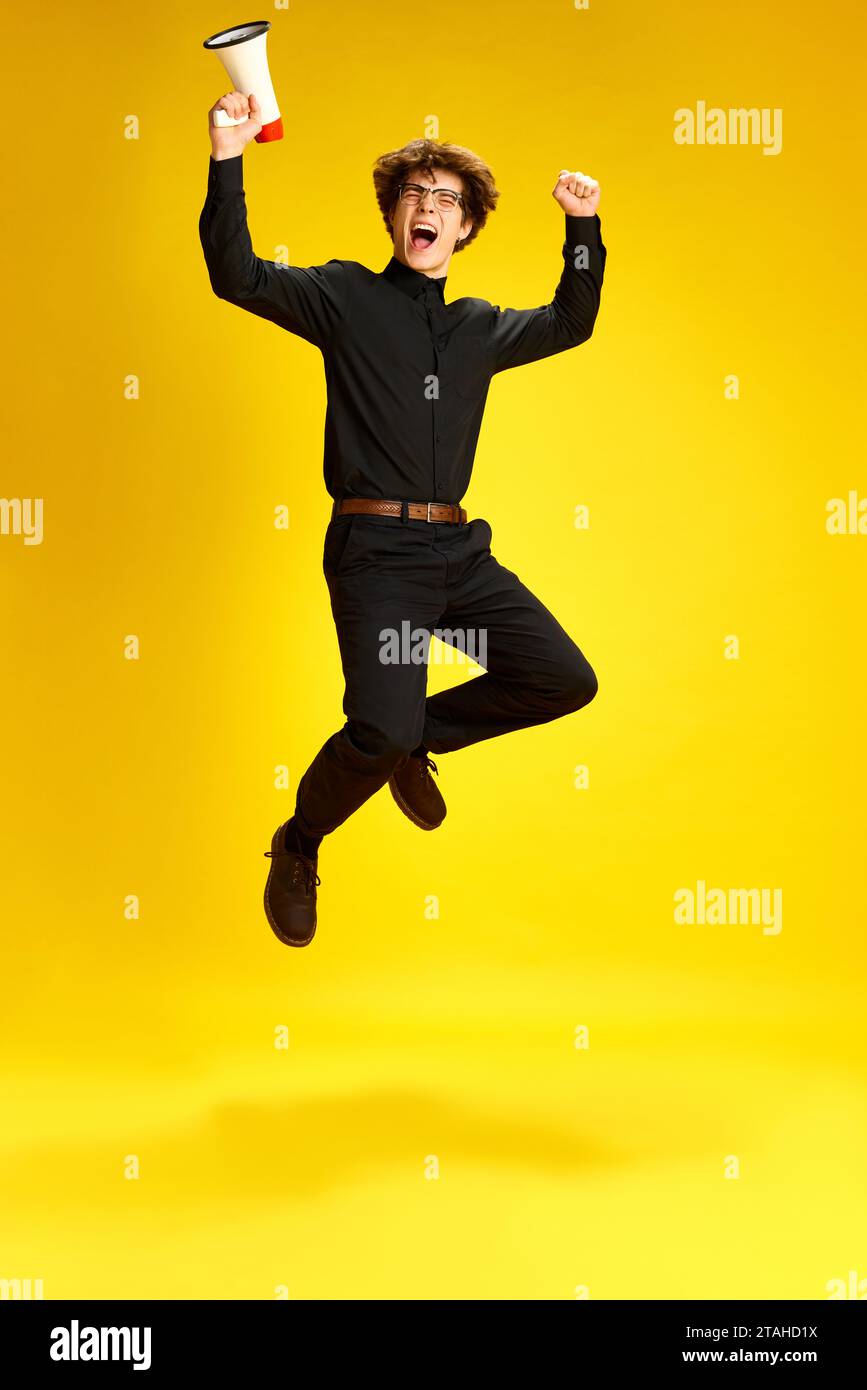 Young man shouting, screaming important good news to megaphone while ...