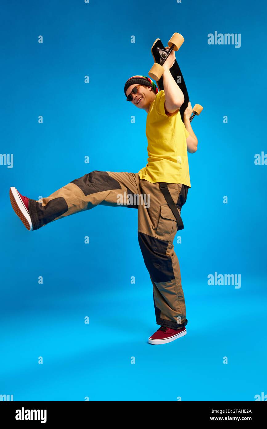 Full-length portrait of positive, smiling man dressed in rastaman ...