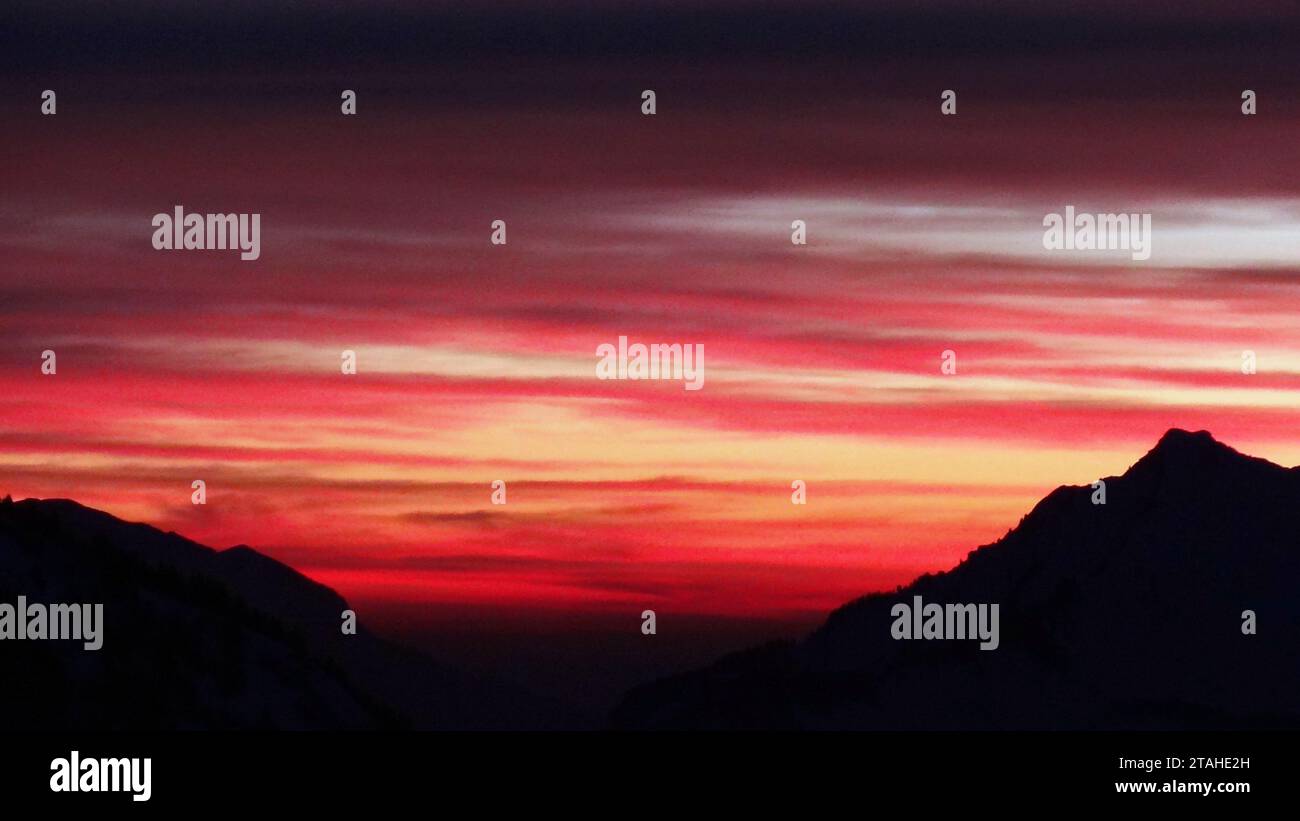 Golden hour pink clouds on blue sky above a mountain range Stock Photo ...