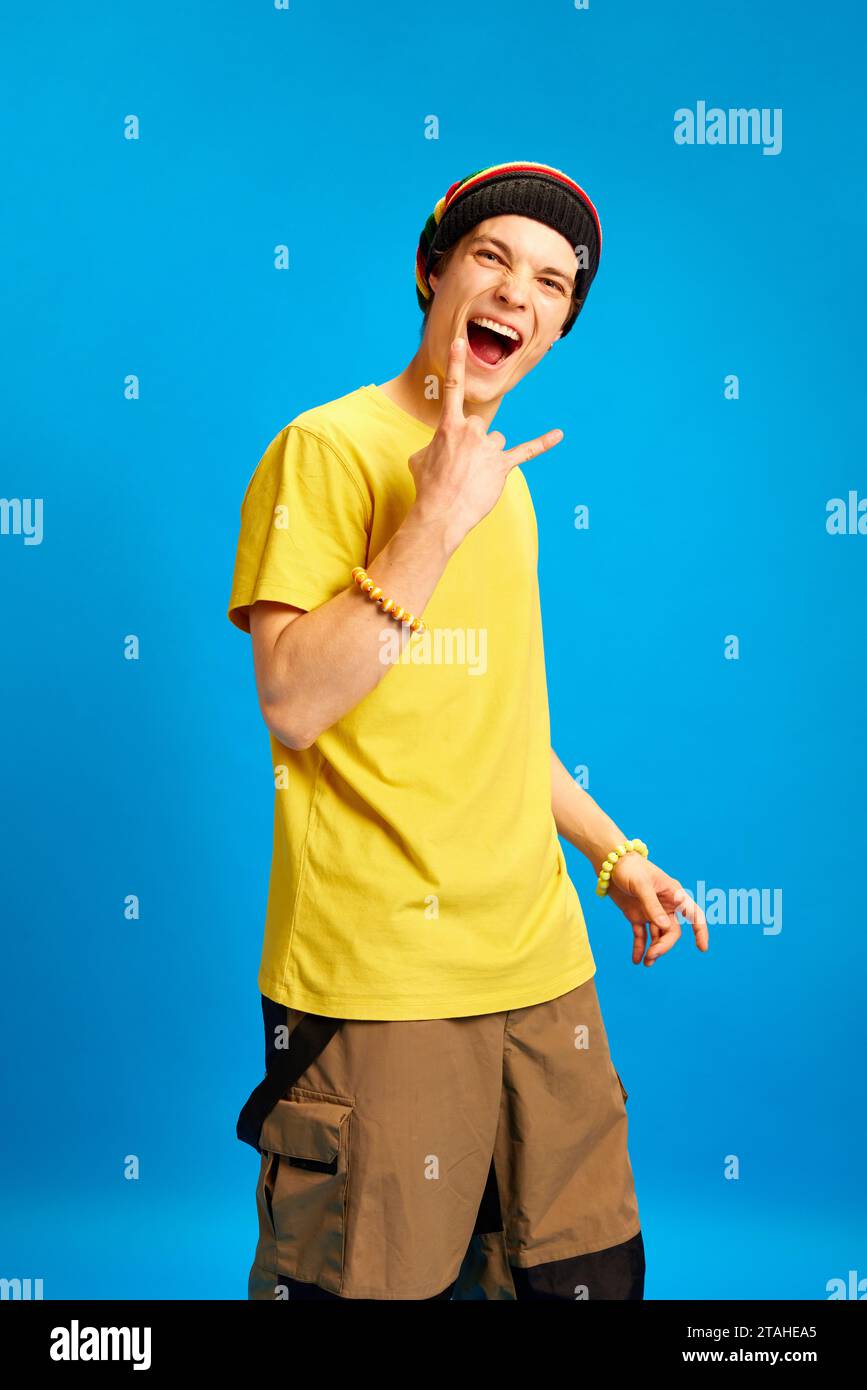 Happy shouting young man wearing rastaman, reggae style outfit showing ...