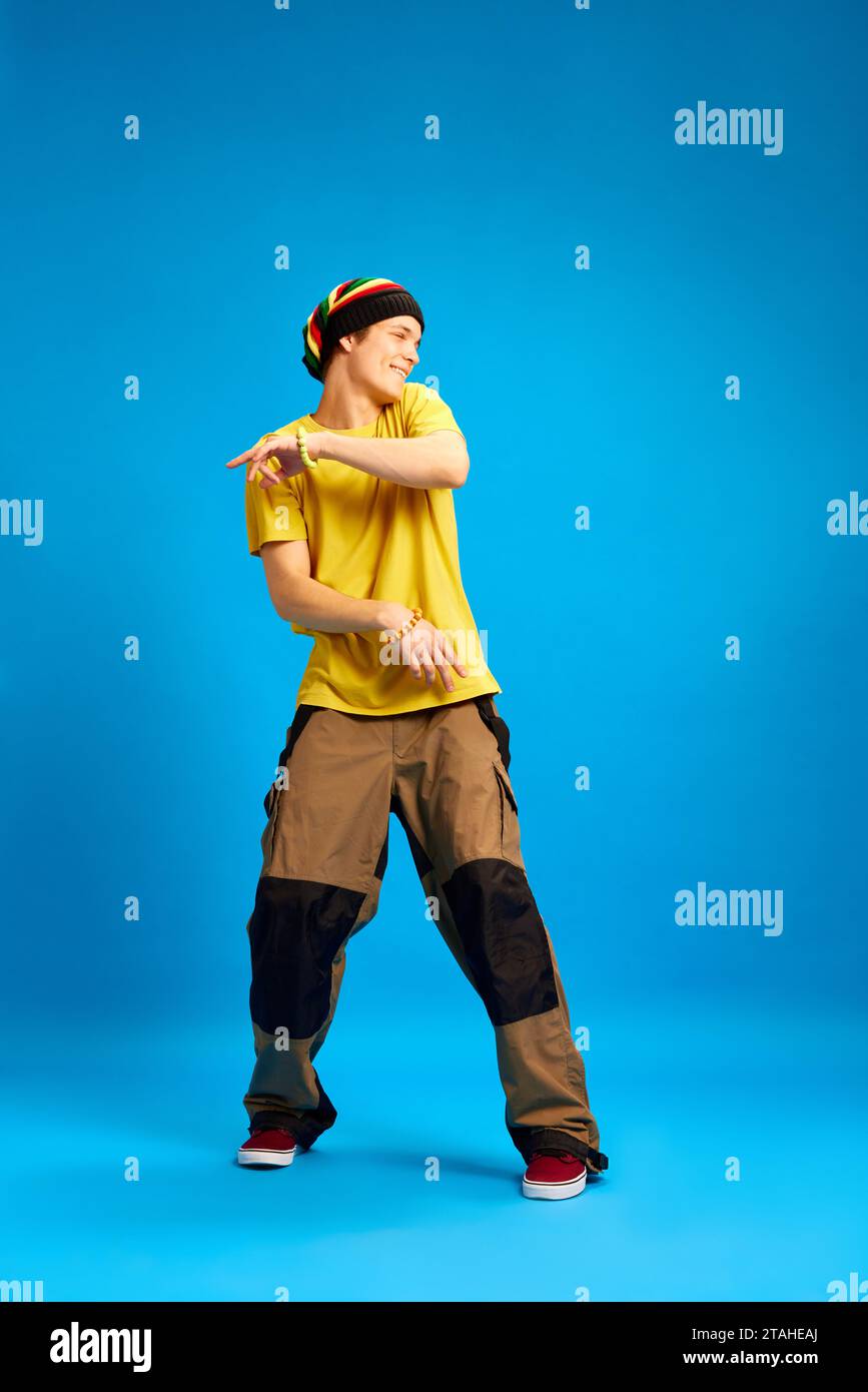 Positive, smiling young man, rastaman dancing while listening music in ...