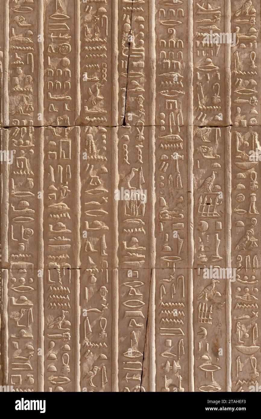Small egyptian hieroglyphs carved on golden wall Stock Photo - Alamy