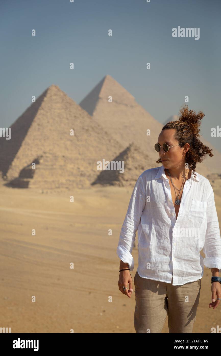 Young man with hairbun and sunglasses, at the Pyramids of Gyza complex ...