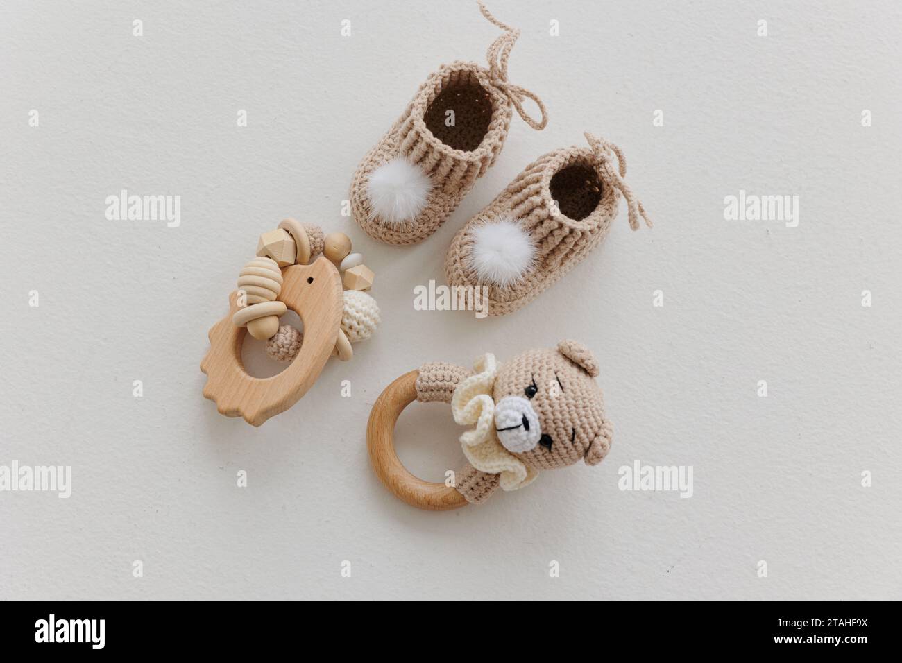 Newborn baby booties and wooden rattles on a white background. Concept ...