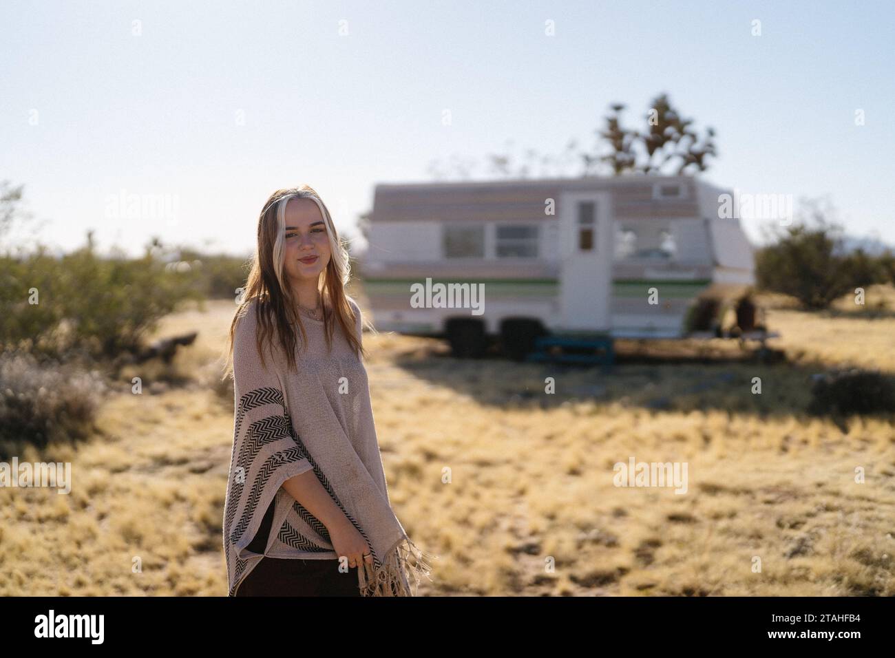 girl walking in front of camper in the Joshua tree California desert ...