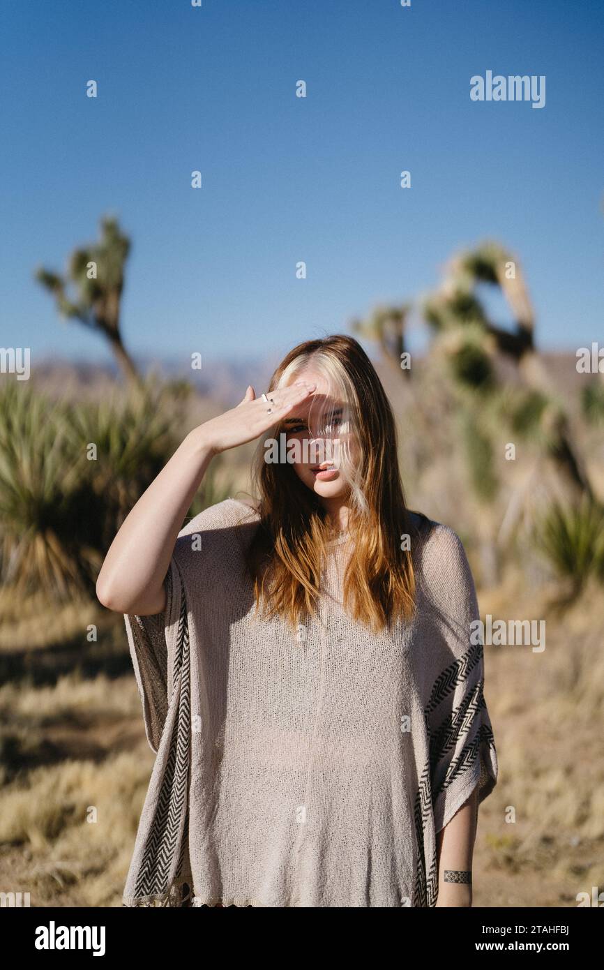 Girl shielding her eyes in the sun in Joshua tree California Stock ...