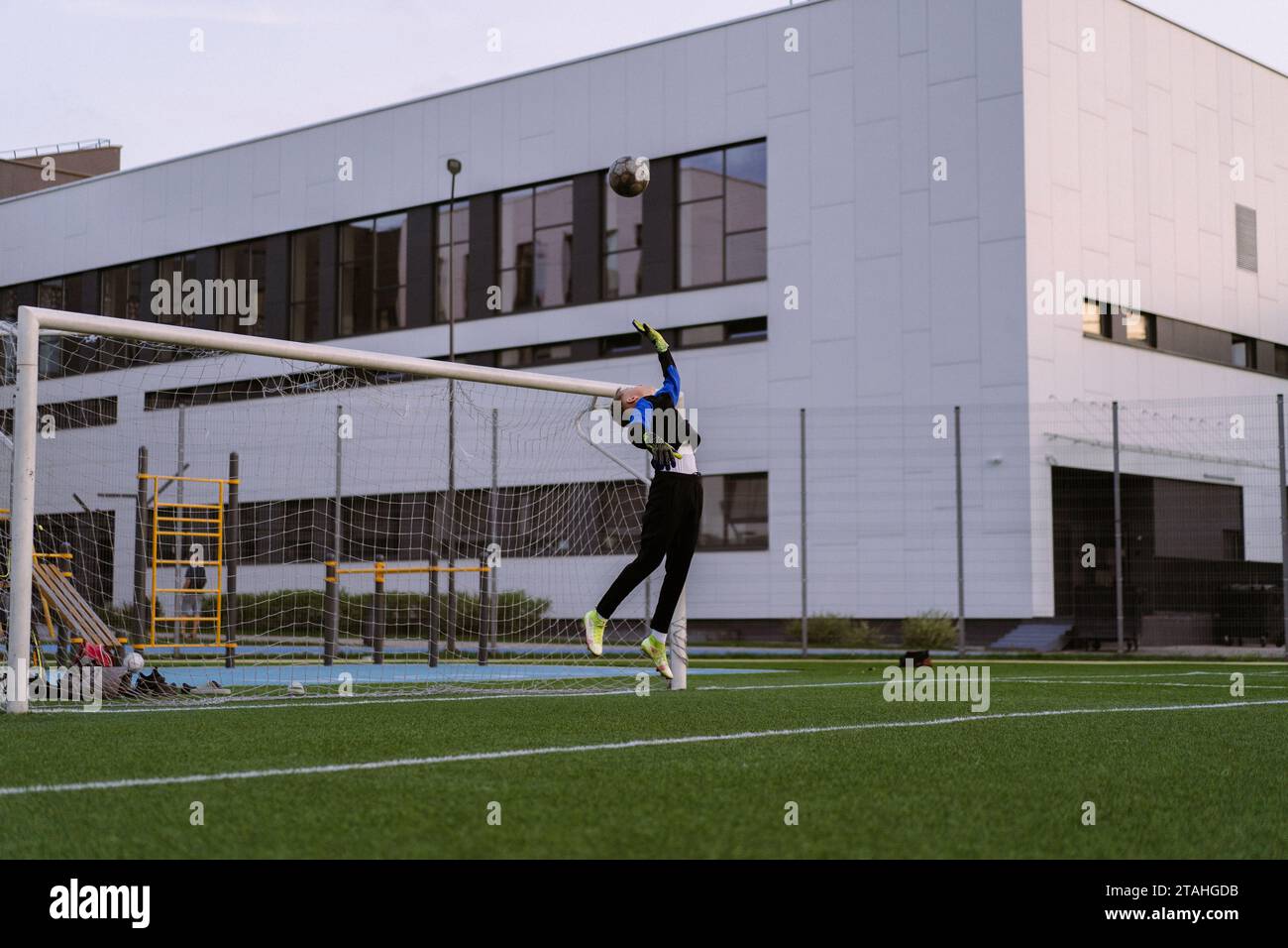 Kids playing soccer, boy goalkeeper catches ball in goal Stock Photo ...