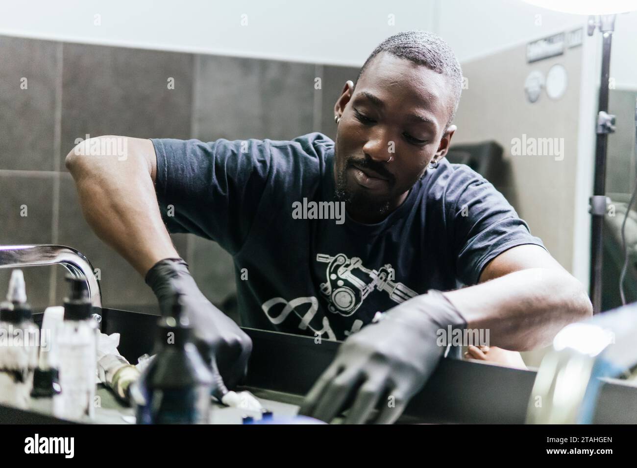 tattoo artist man taking valesina for a tattoo Stock Photo - Alamy
