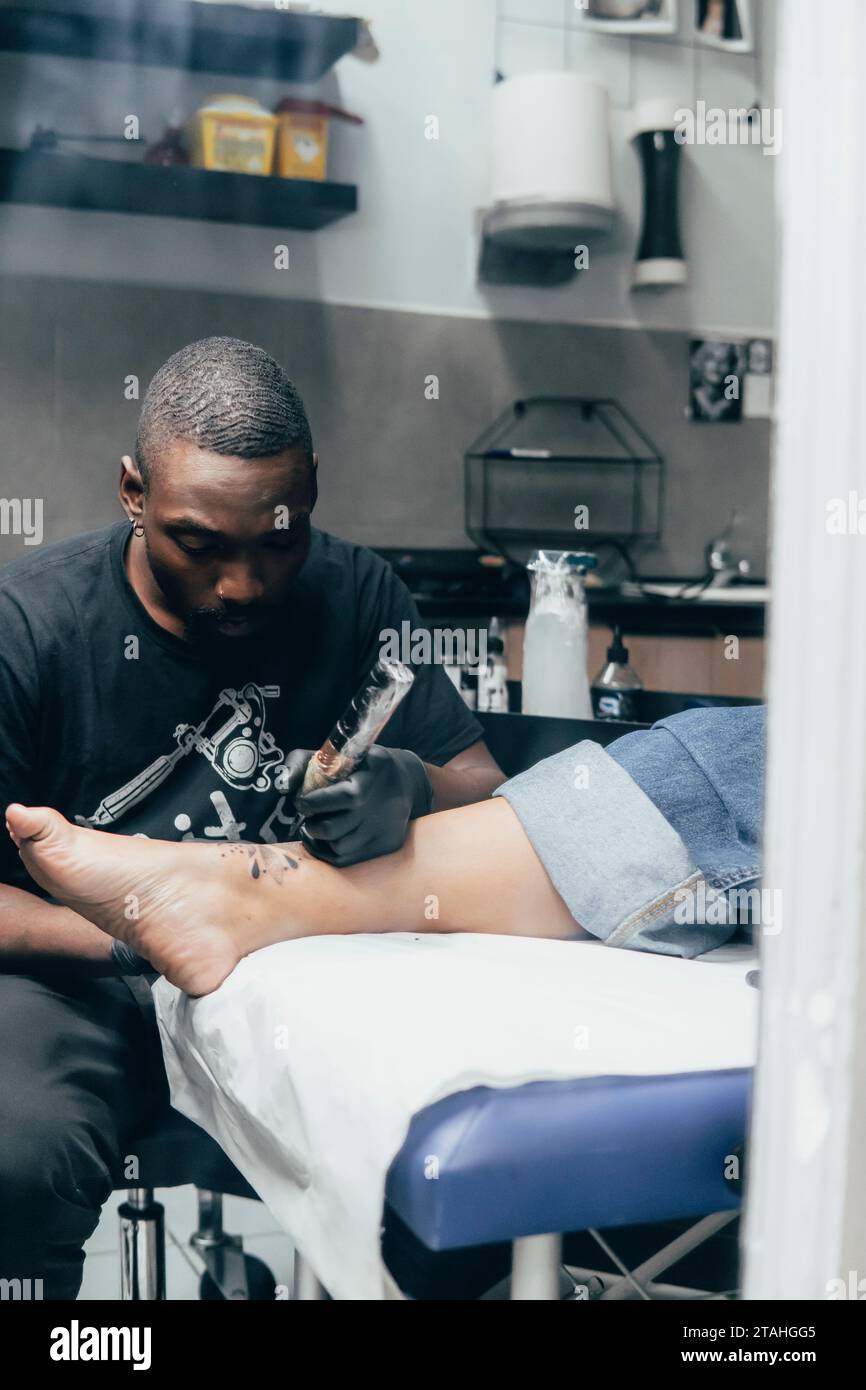 man tattooing tattoo in his studio Stock Photo - Alamy