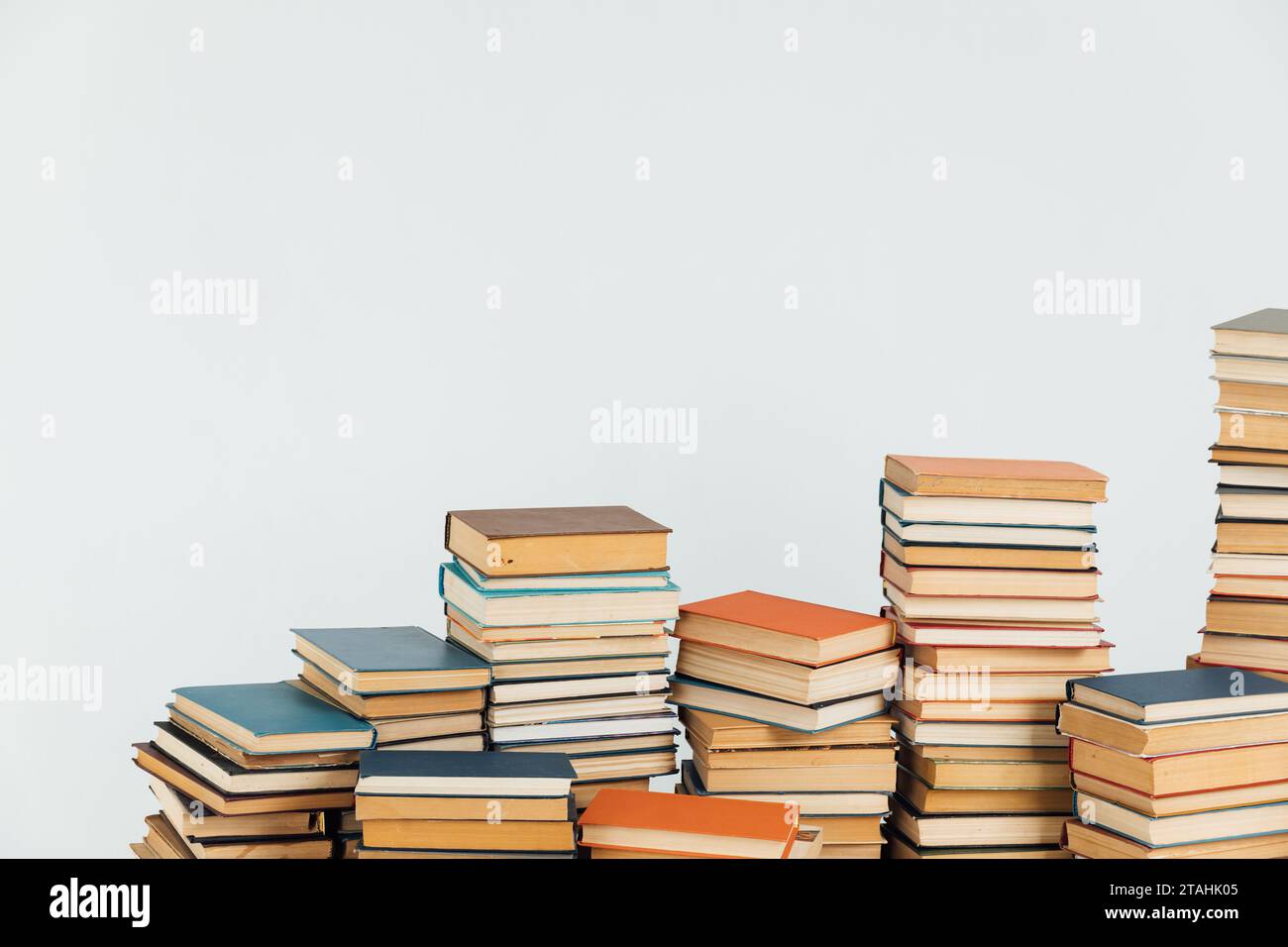 Lots of stacks of educational books on white school university library ...