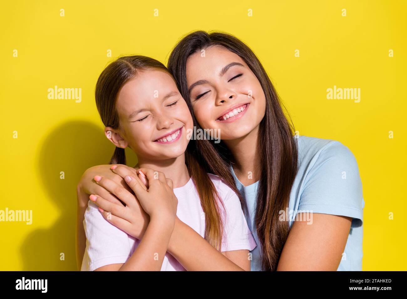 Photo of cheerful dreamy small siblings dressed t-shirts closed eyes ...