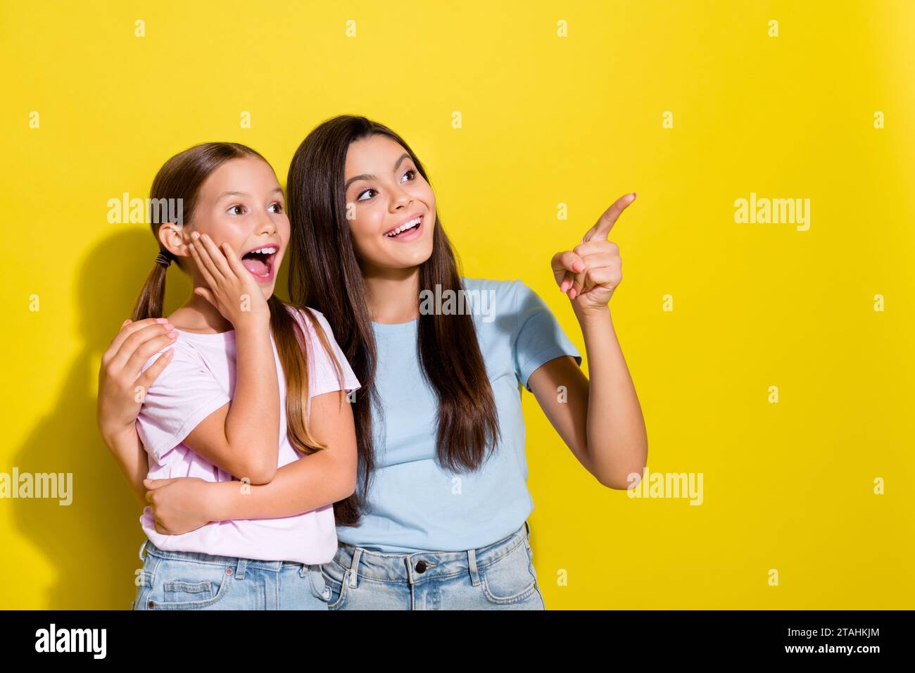 Photo of shiny positive small siblings dressed t-shirts showing finger ...