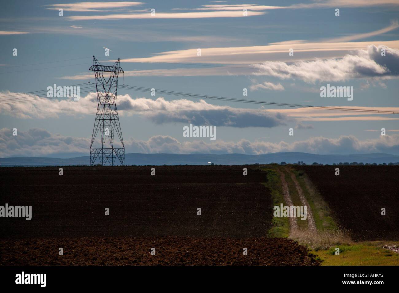 Isolated high voltage electrical tower on a crop field Stock Photo - Alamy