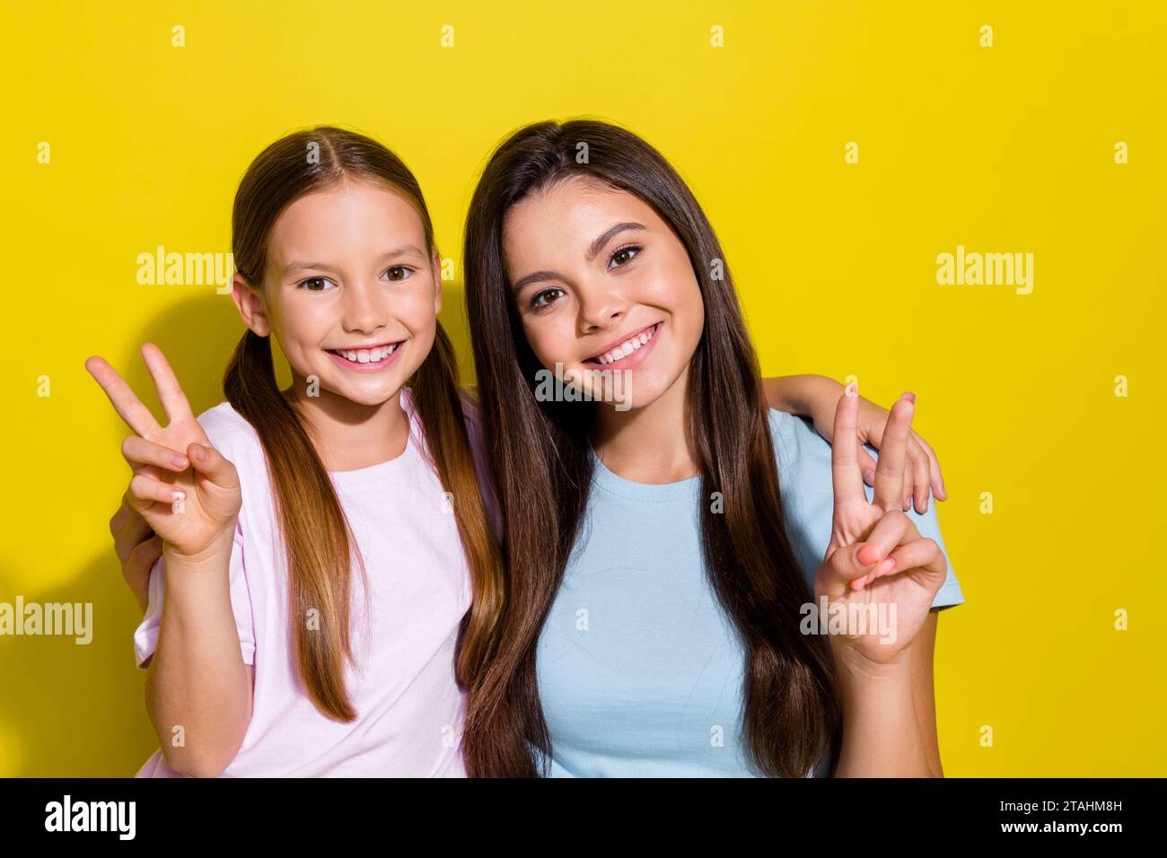 Photo of cheerful positive small siblings dressed t-shirts cuddling ...