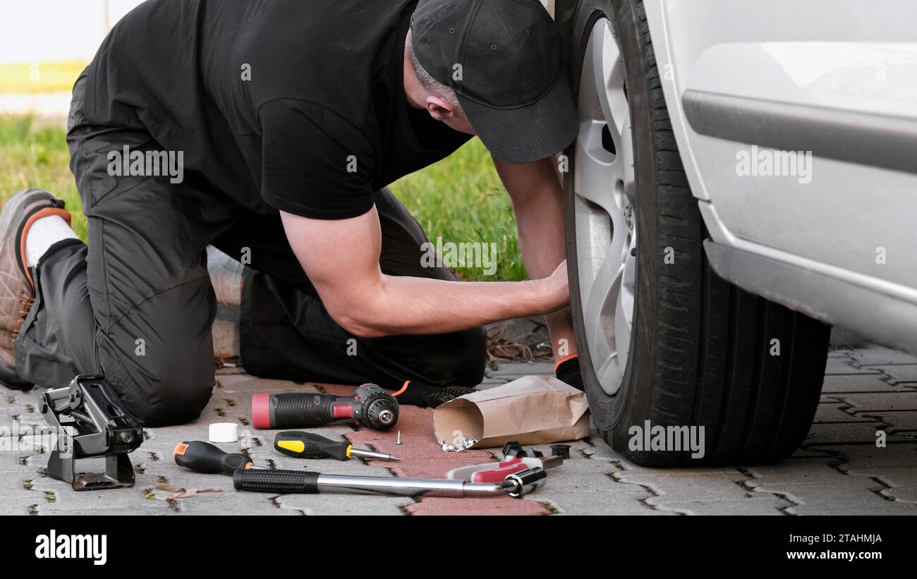 Driver Repairs Car Using Tools On Street Stock Photo - Alamy