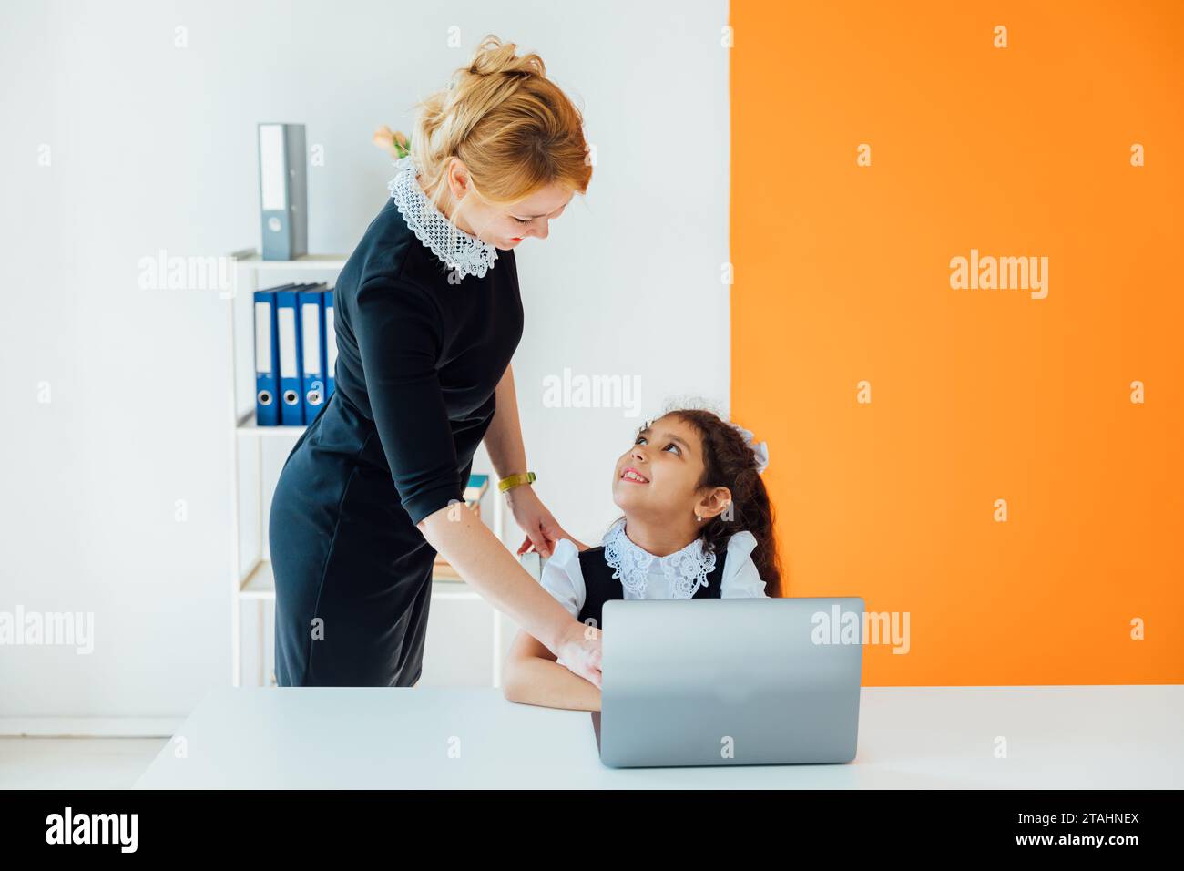 Teacher teaching girl on computer lesson at school Stock Photo - Alamy