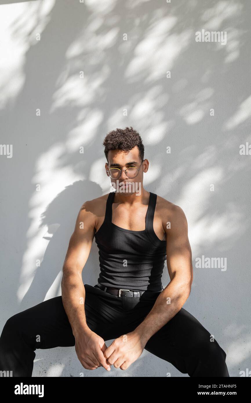 Relaxed and stylish, muscular and young cuban man in black outfit and ...